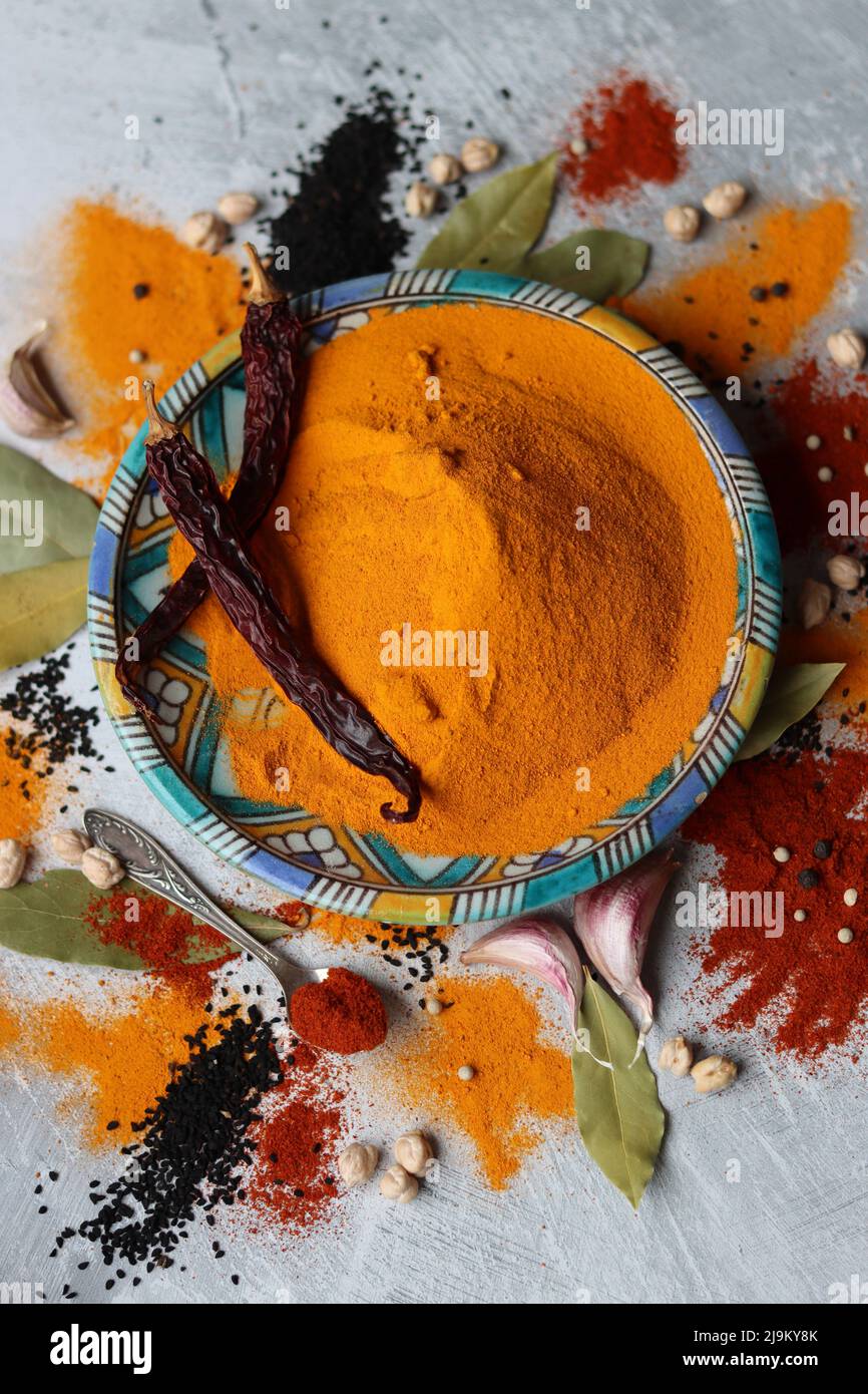 Colorful still life with turmeric powder on blue handmade plate. Close ...