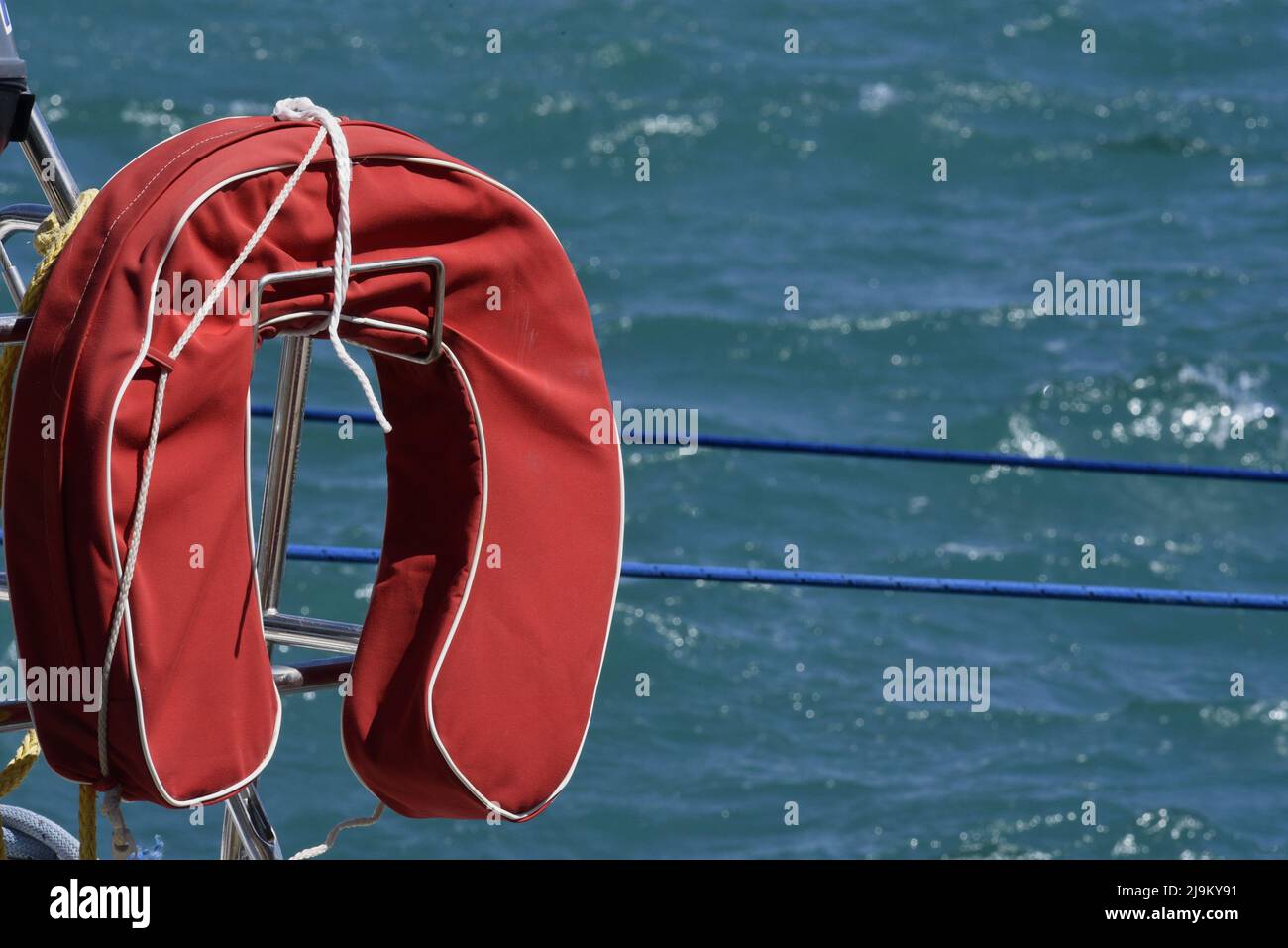 Sailboat red floating rescue life saver tied on the wired chrome ...