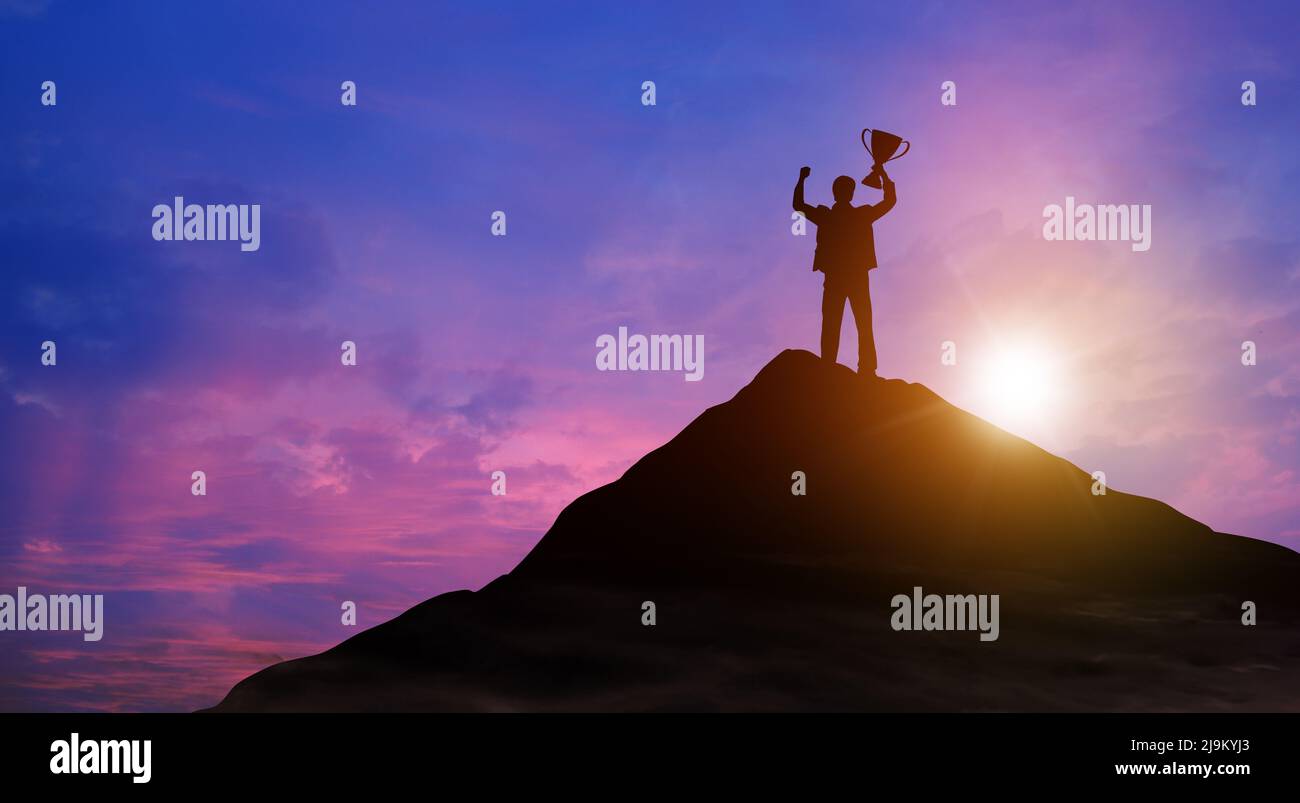 Silhouette victory businessman with trophy climbed to the top of ...