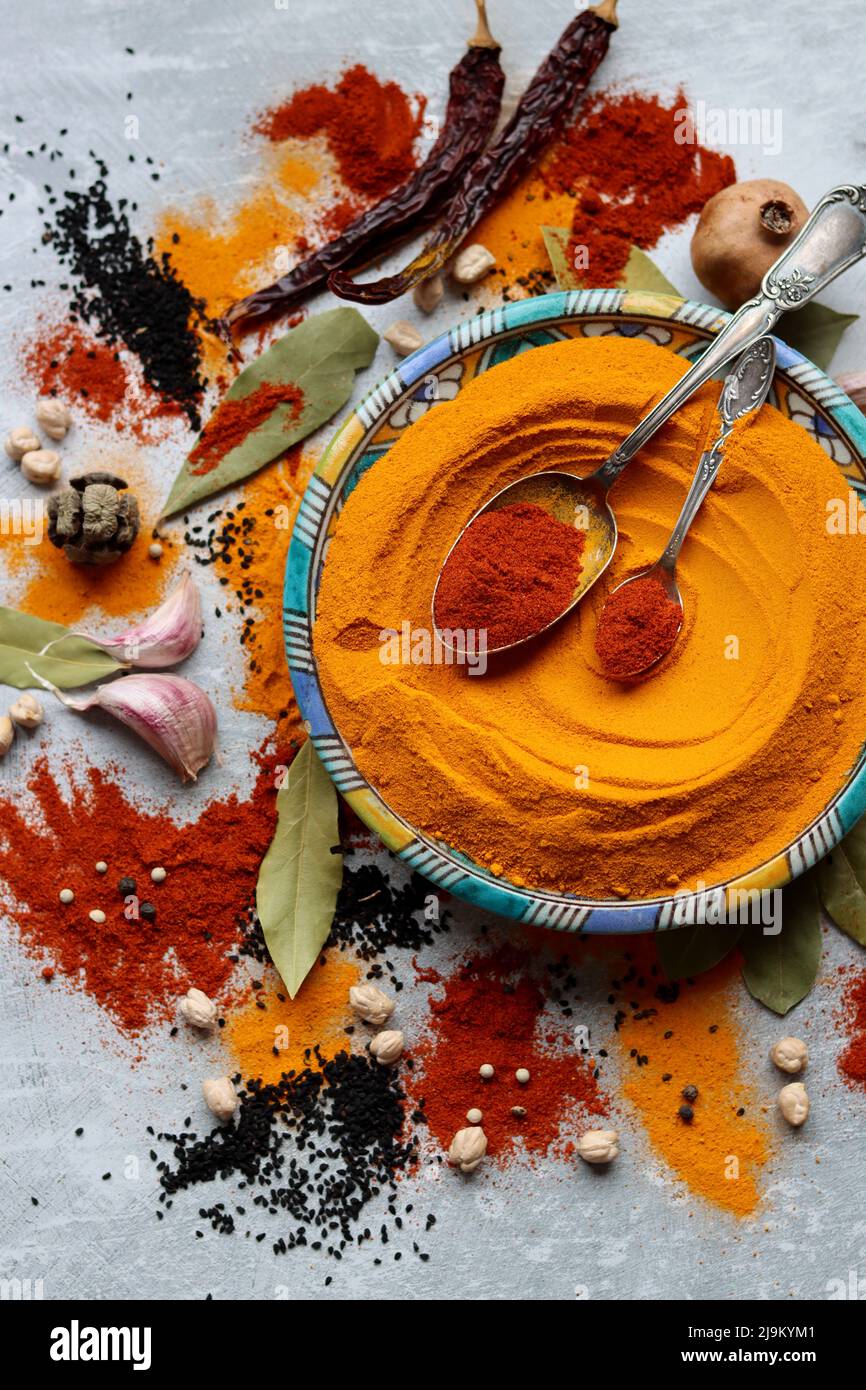 Colorful still life with turmeric powder on blue handmade plate. Close ...