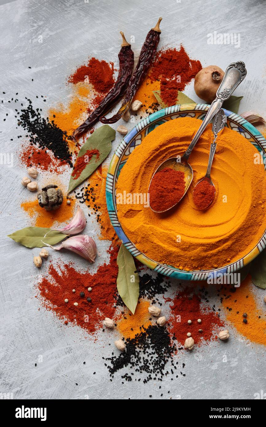 Colorful still life with turmeric powder on blue handmade plate. Close ...