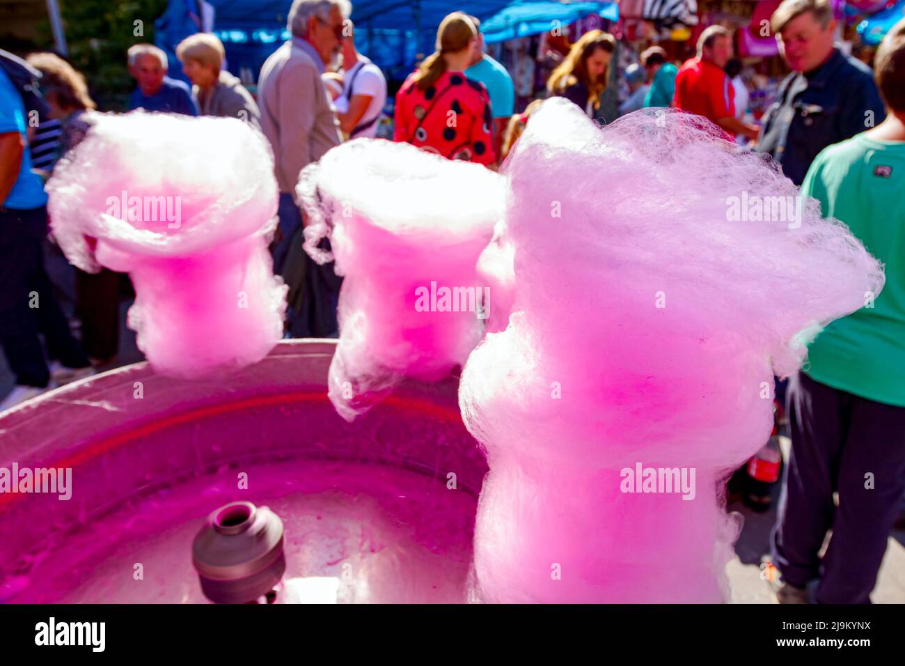 Process of making pink sweet cotton wool on spinning wooden stick in a ...