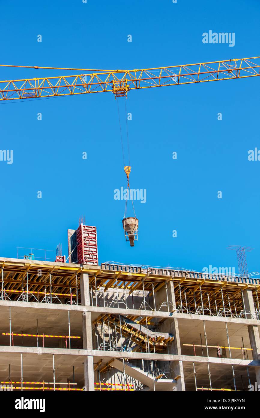 A crane lifts concrete for a modern metal-concrete structure of a ...