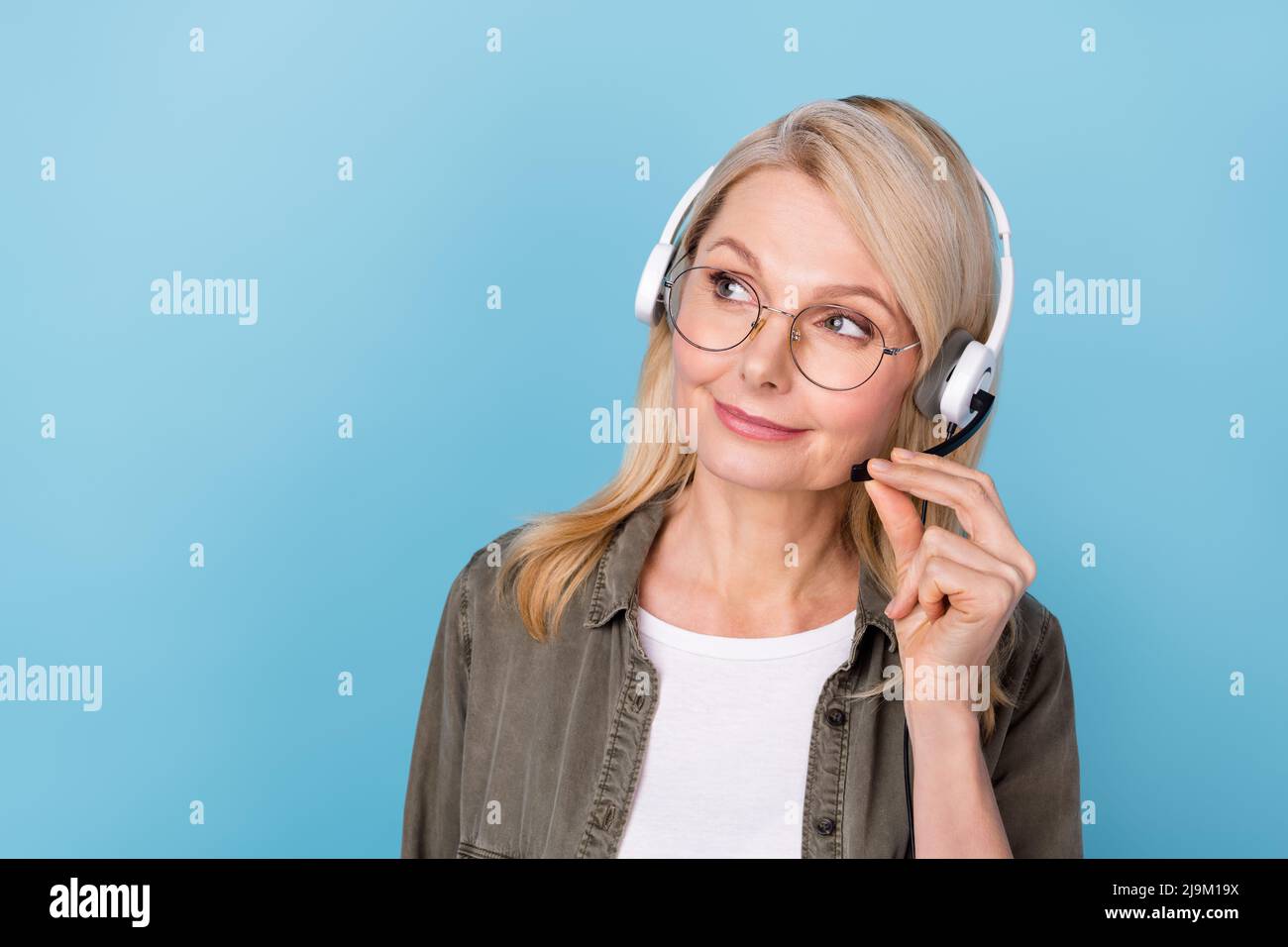 Photo of middle aged lady secretary work help desk use earphones mic ...