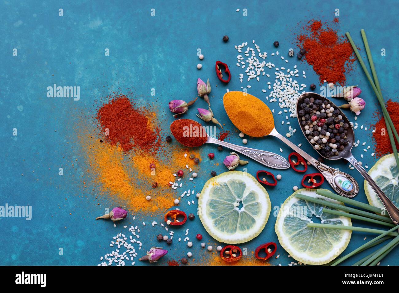 Still life with silver spoons, turmeric , paprika powder, bay leaf and ...