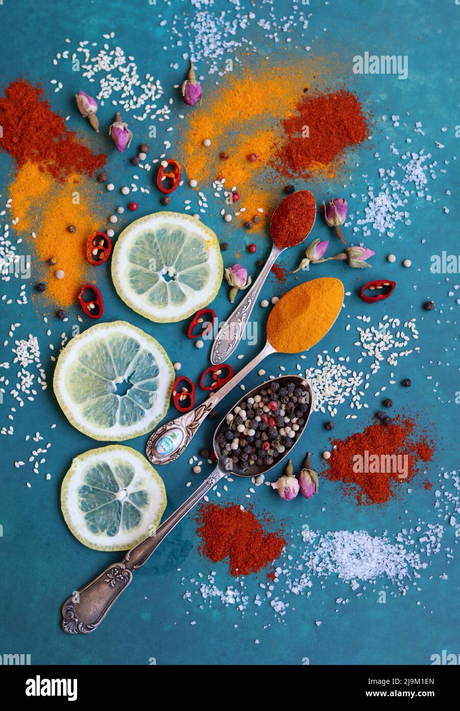 Still life with silver spoons, turmeric , paprika powder, bay leaf and ...