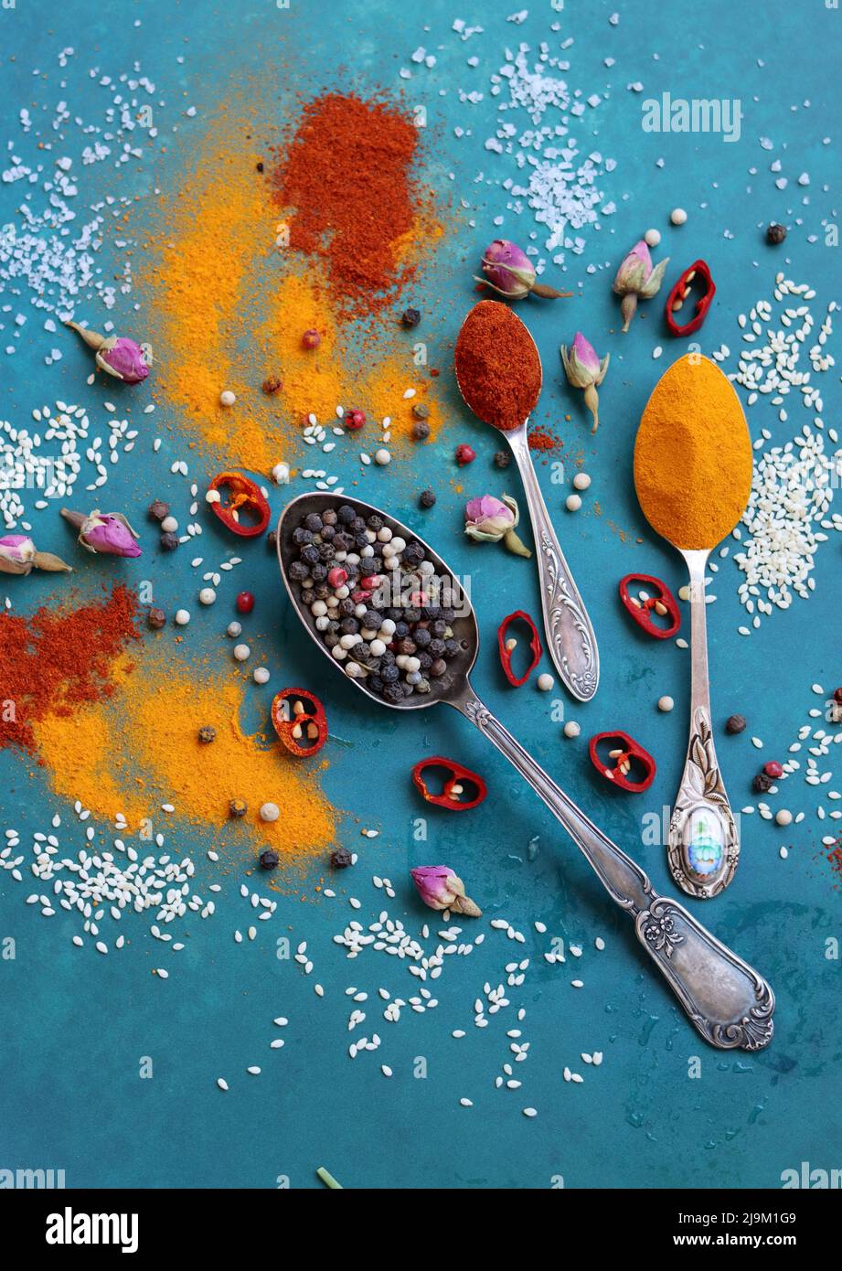 Still life with silver spoons, turmeric , paprika powder, bay leaf and ...