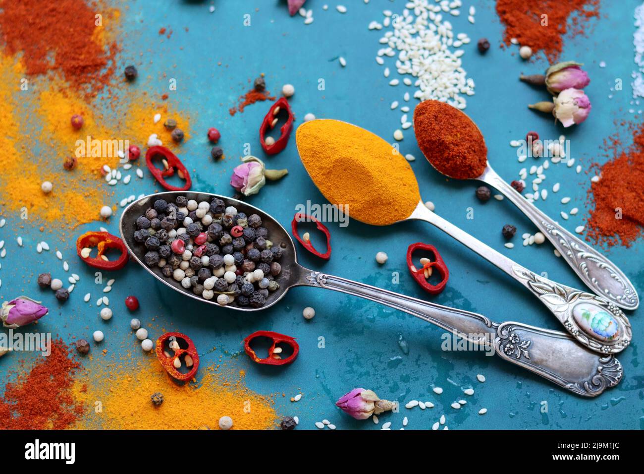 Spoons with spices close up photo. Turmeric, paprika powder, chick peas ...