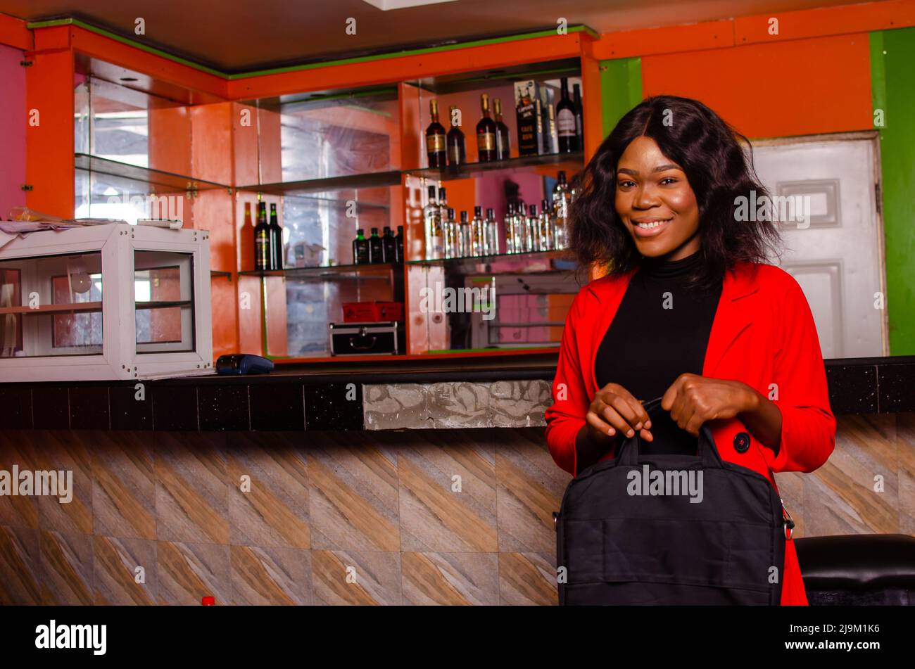 beautiful cafe manager smiling in the cafe holding laptop bag Stock ...