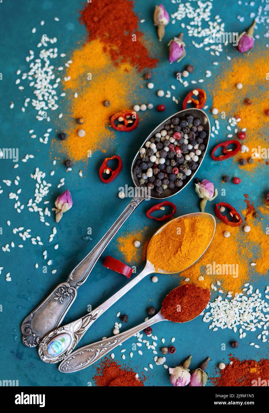 Still life with silver spoons, turmeric , paprika powder, bay leaf and ...