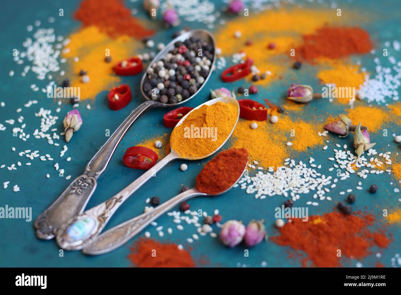 Still life with silver spoons, turmeric , paprika powder, bay leaf and ...