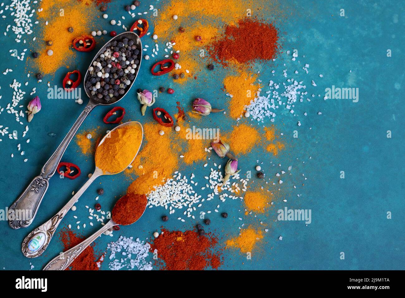 Still life with silver spoons, turmeric , paprika powder, bay leaf and ...