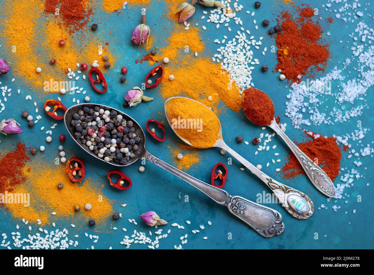 Still life with silver spoons, turmeric , paprika powder, bay leaf and ...