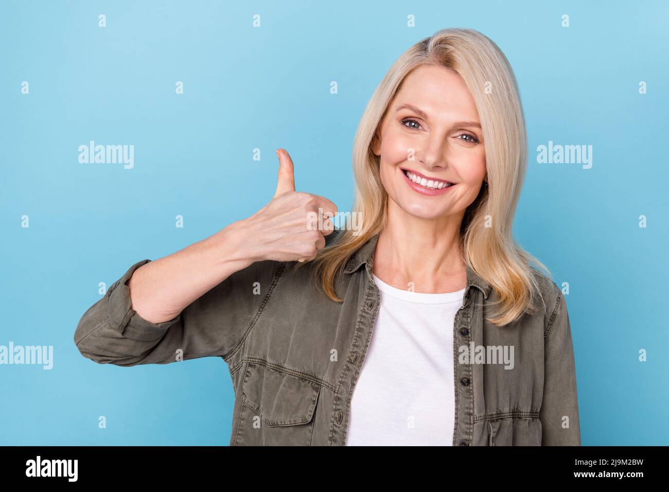 Portrait of positive middle aged lady promoter make thumb up symbol ...