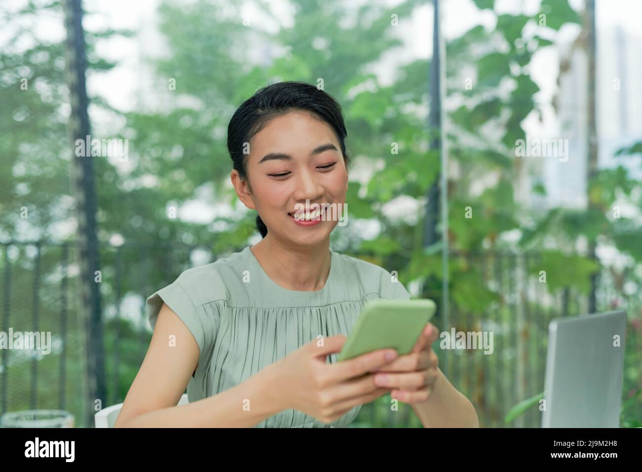 Happy young elegant businesswoman scrolling in smartphone while ...