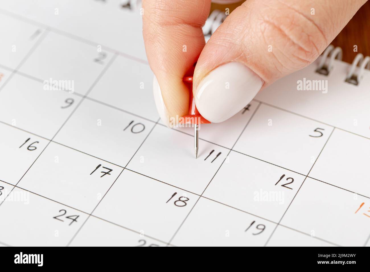 red Hand pin stuck on the day of the month in the calendar, business ...