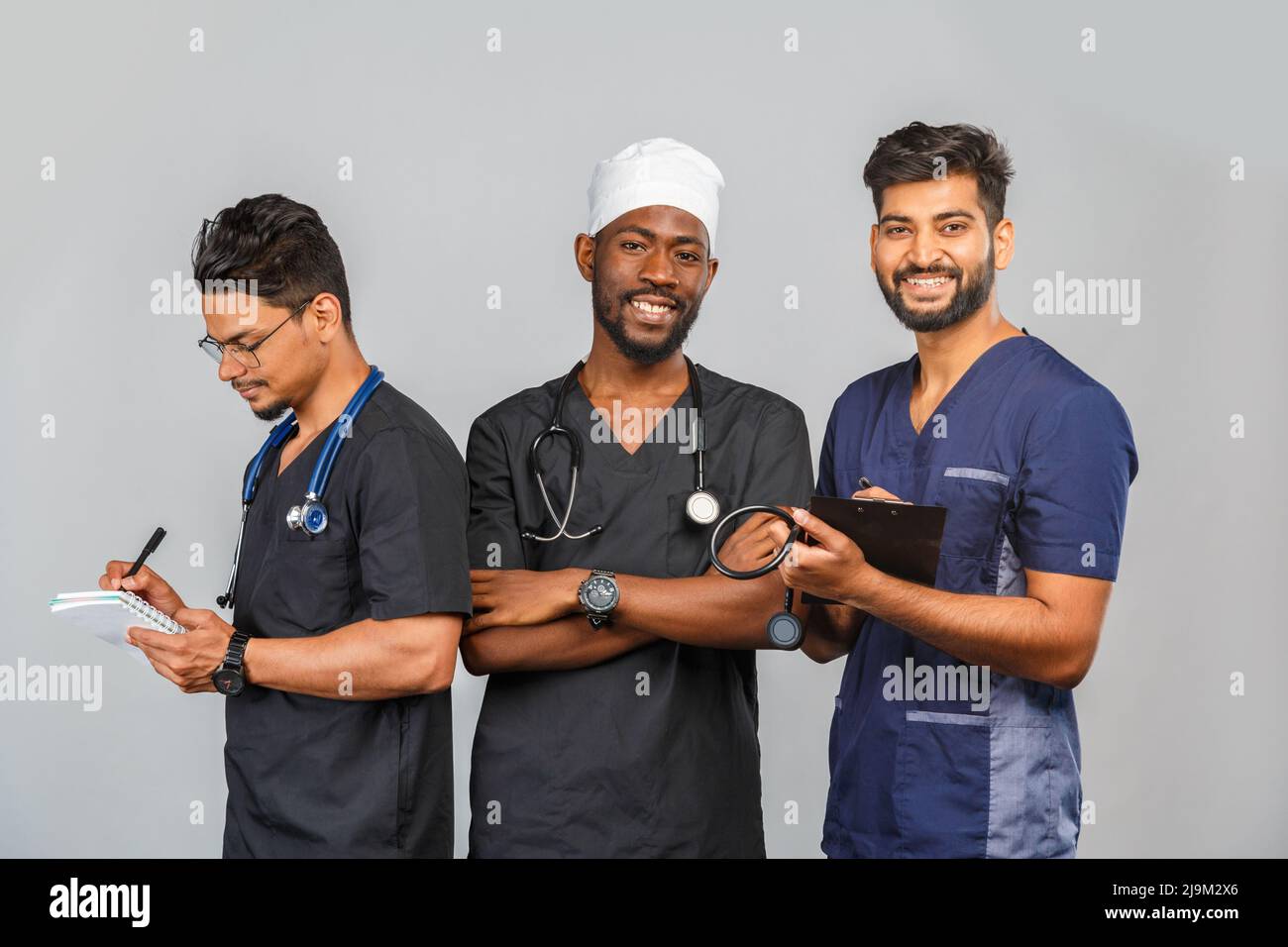 attractive medical team standing together over light gray background ...