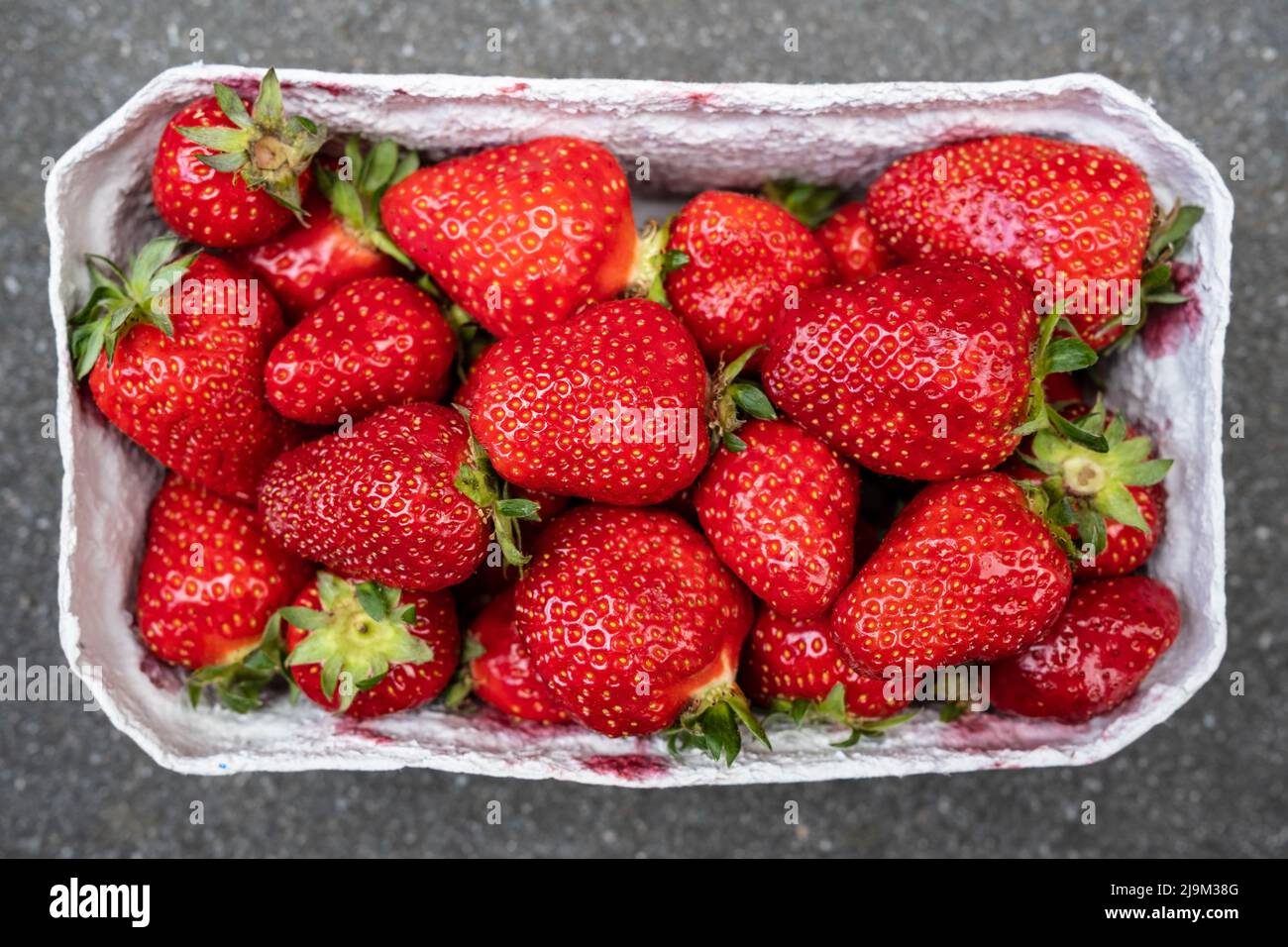 Delicious fragrant strawberries in a paper container. Red ripe berry is ...