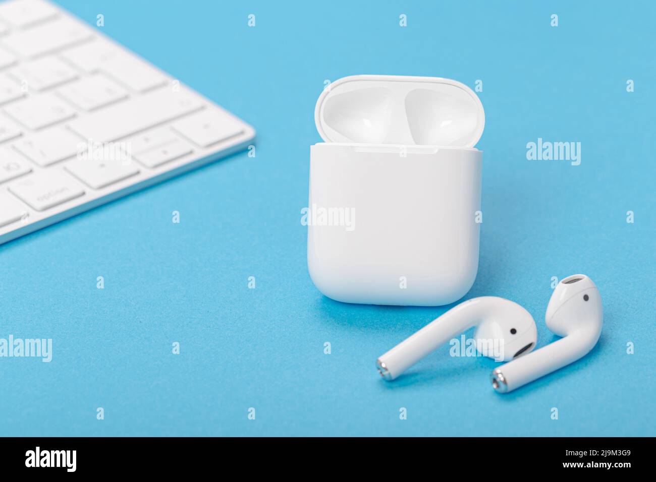 Modern wireless bluetooth headphones with charging case on a blue ...