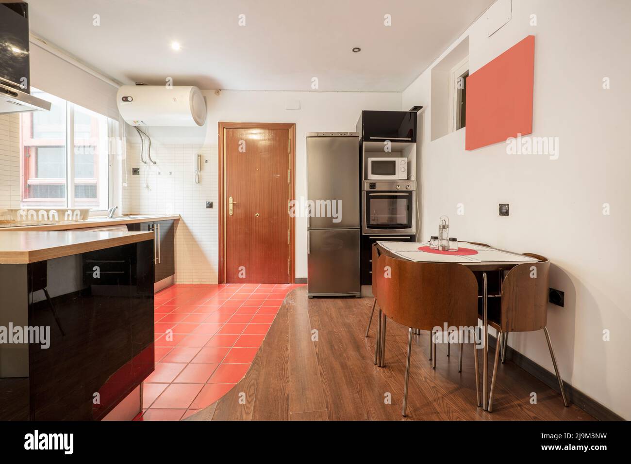 Kitchen with designer dining table with wooden and metal chairs and ...