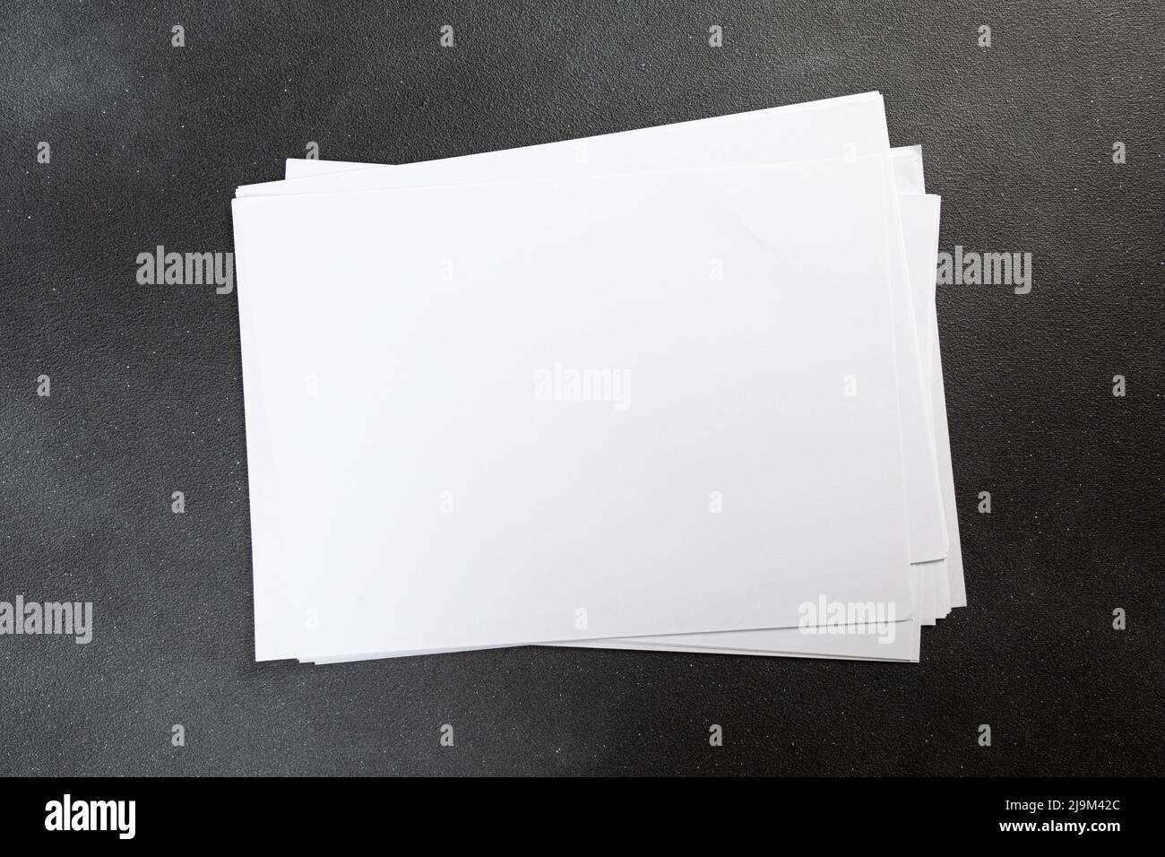 White business card sheet of paper a4 stack on a dark table. Clean ...