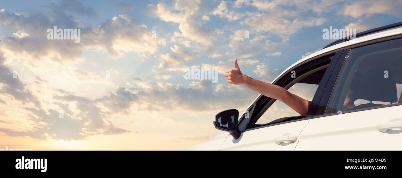 Happy man holding hand outside open window car with sky clouds ...