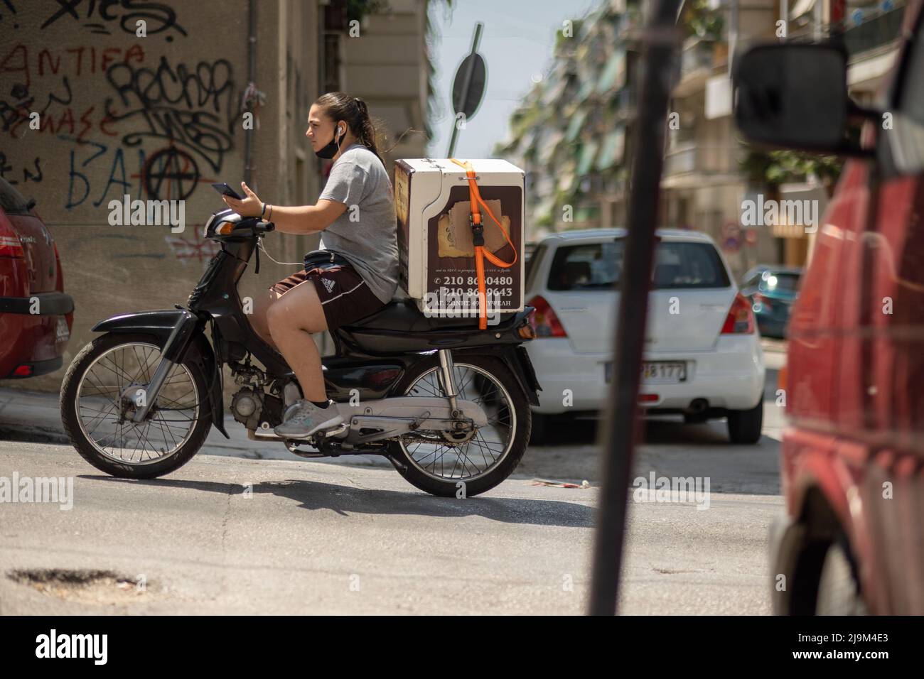 Making deliveries a delivery rider with a mobile phone Stock Photo - Alamy
