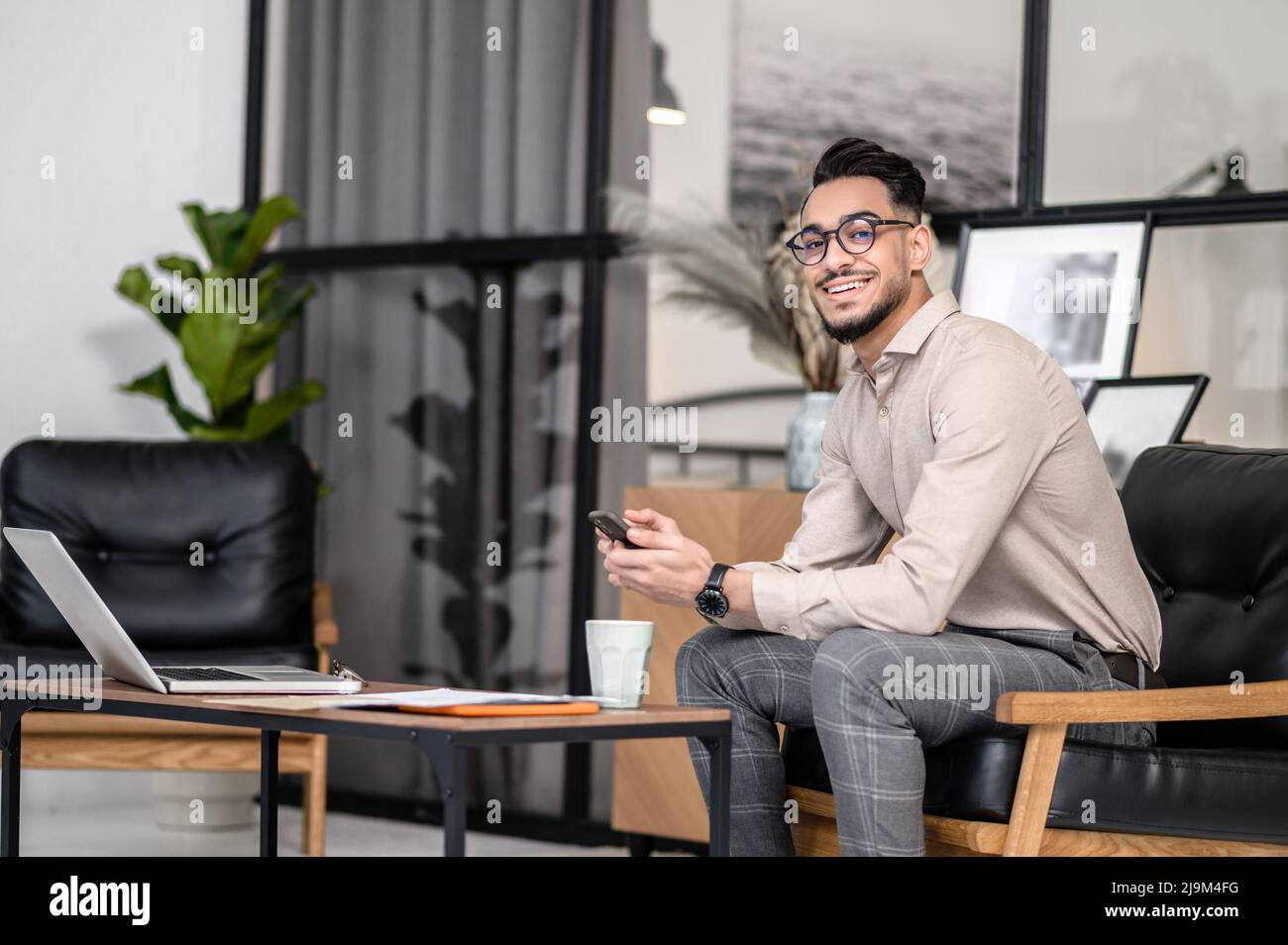 A young good-looking businessman sitting in the office Stock Photo - Alamy