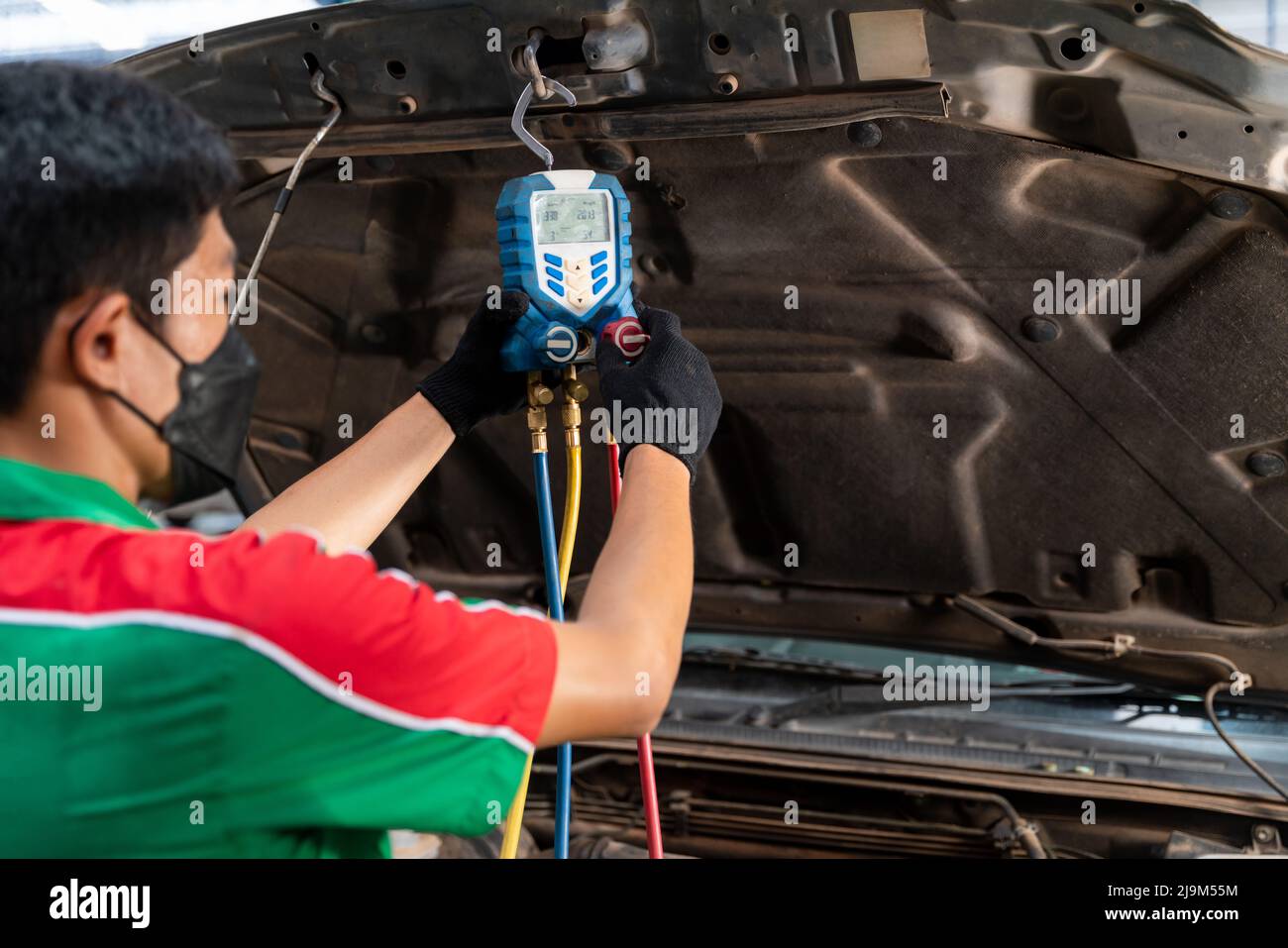 Auto mechanic checking and fill the car's air conditioner in Car repair ...
