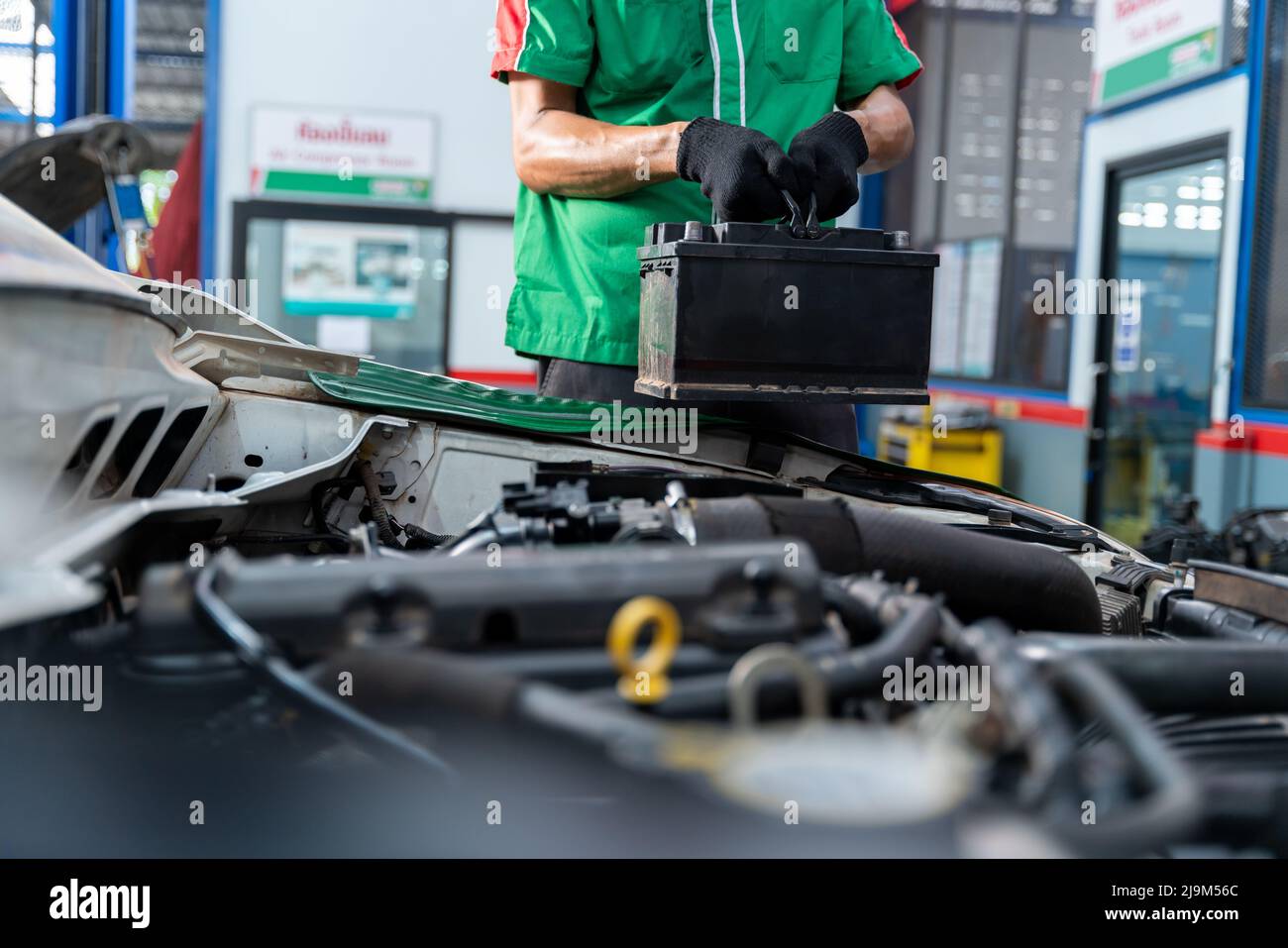 Auto mechanic is about to repair battery for the customers who come to ...