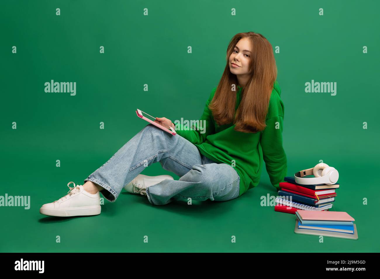 Portrait of young girl, student in casual cloth, hoodie sitting on ...