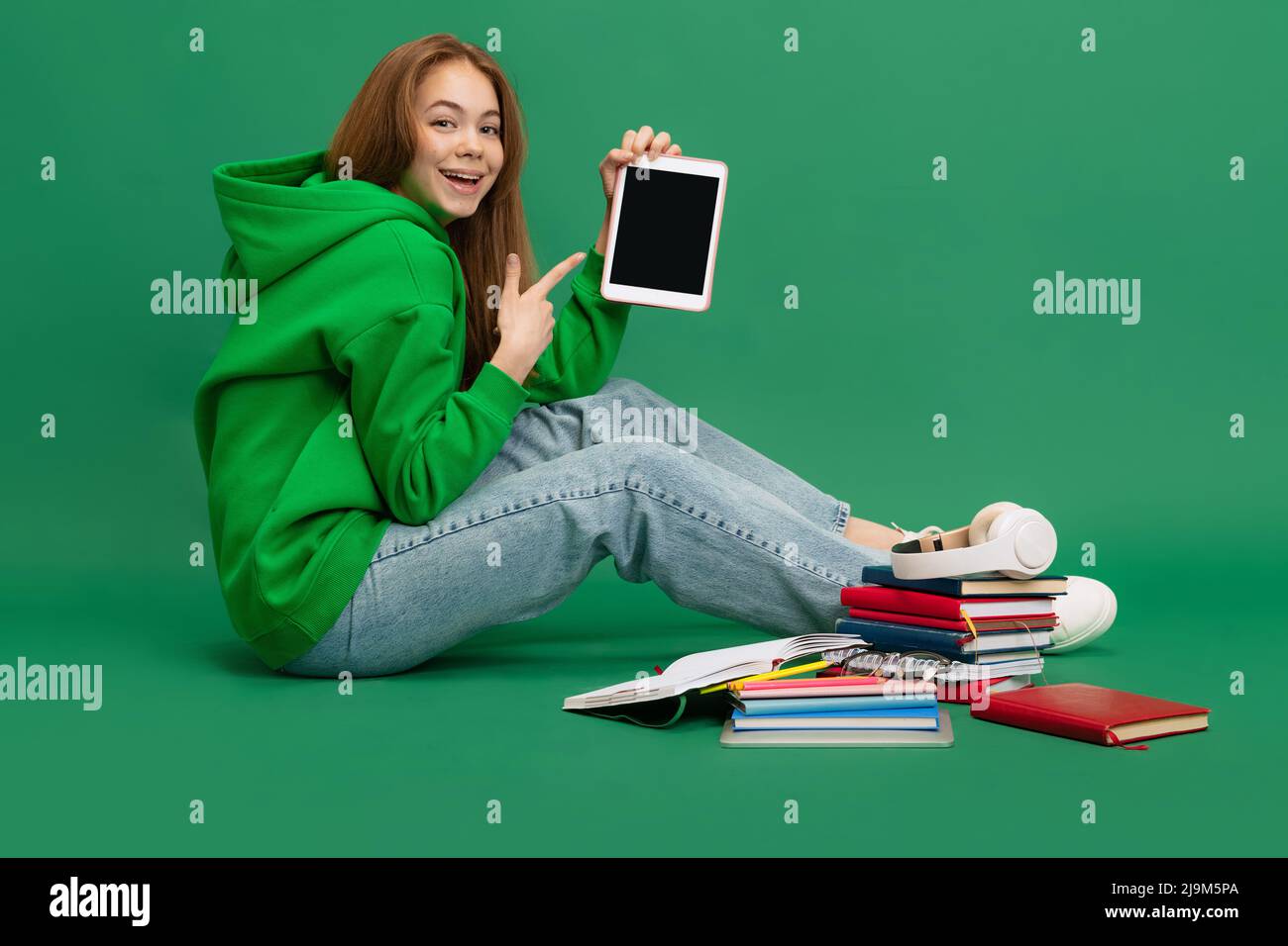 Portrait of young girl, student in casual cloth, hoodie sitting on ...