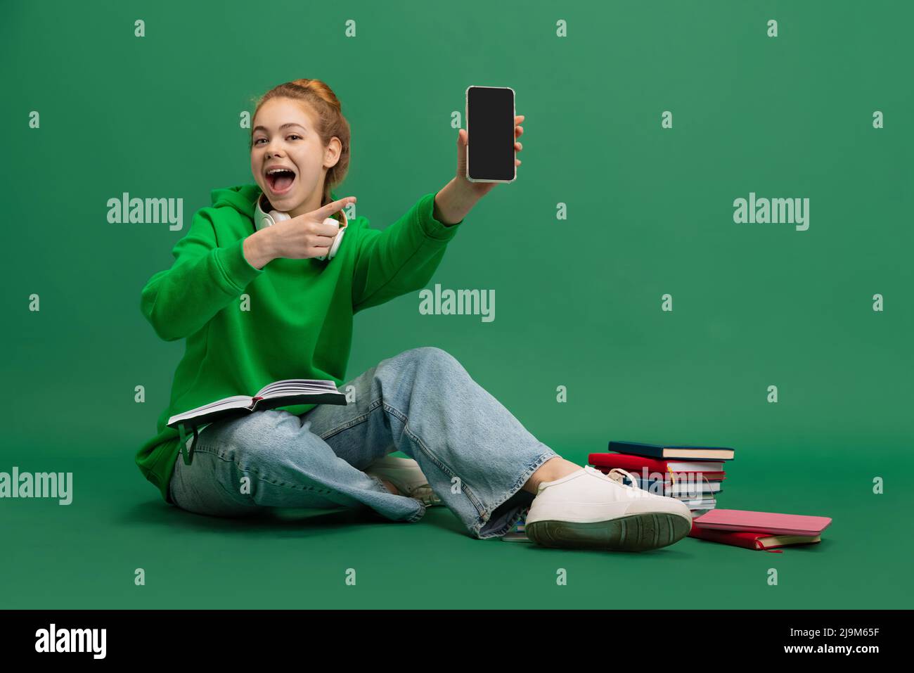 Portrait of young girl, student in casual cloth, hoodie sitting on ...