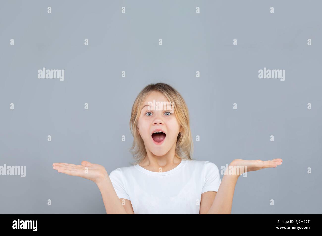 Happy shocked excited surprised child girl holding empty open hands ...