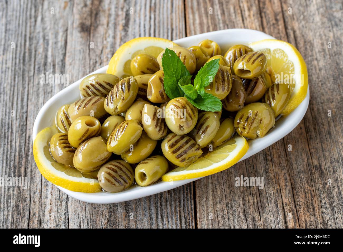 Grilled green olives. natural olive on wood floor background. Healthy ...