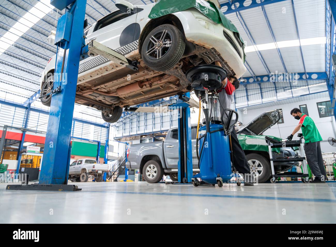 Auto mechanic working in Car repair station paved with epoxy floor and ...