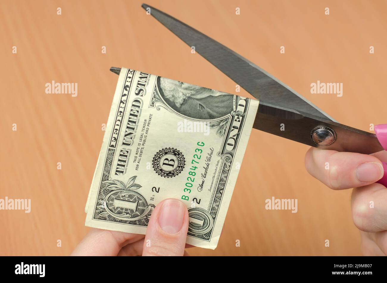 Close-up of female hands cutting one dollar bill with scissors Stock ...