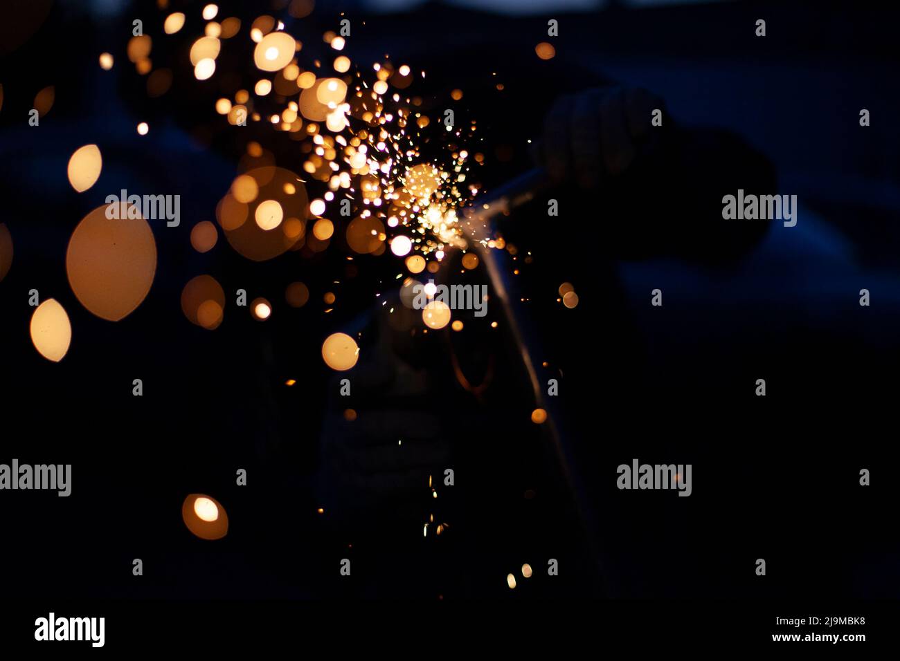 Sparks from grinding metal. Steel processing in workshop. Lights in ...