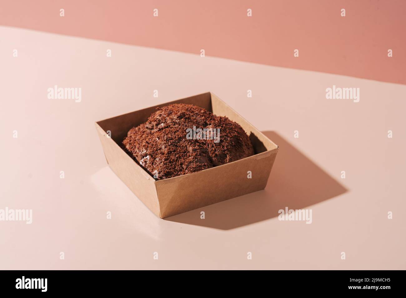 Chocolate cake in box without lid on pink background Stock Photo - Alamy