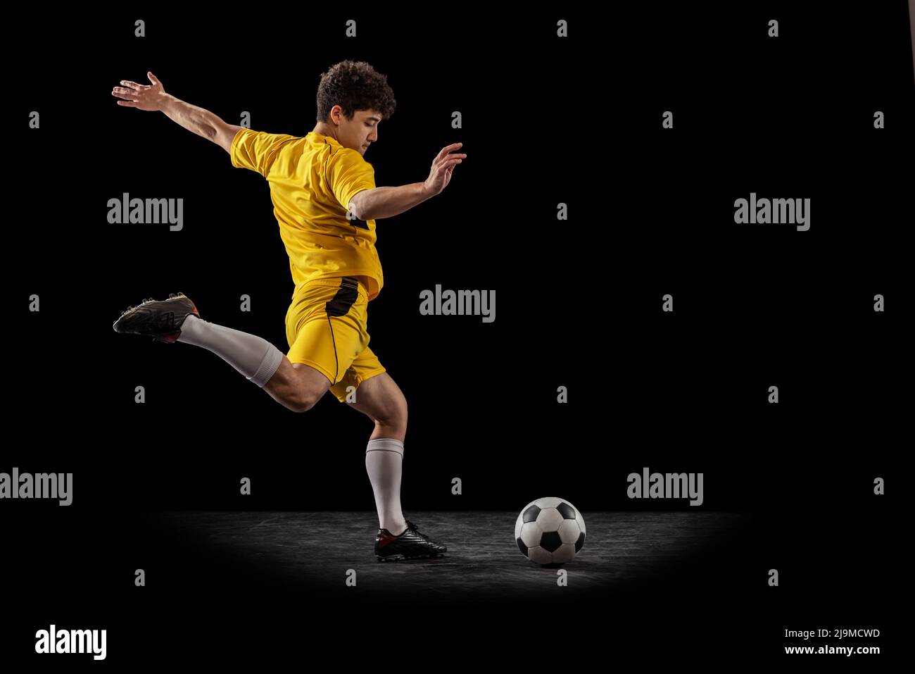 Dynamic portrait of professional football, soccer player training with ...