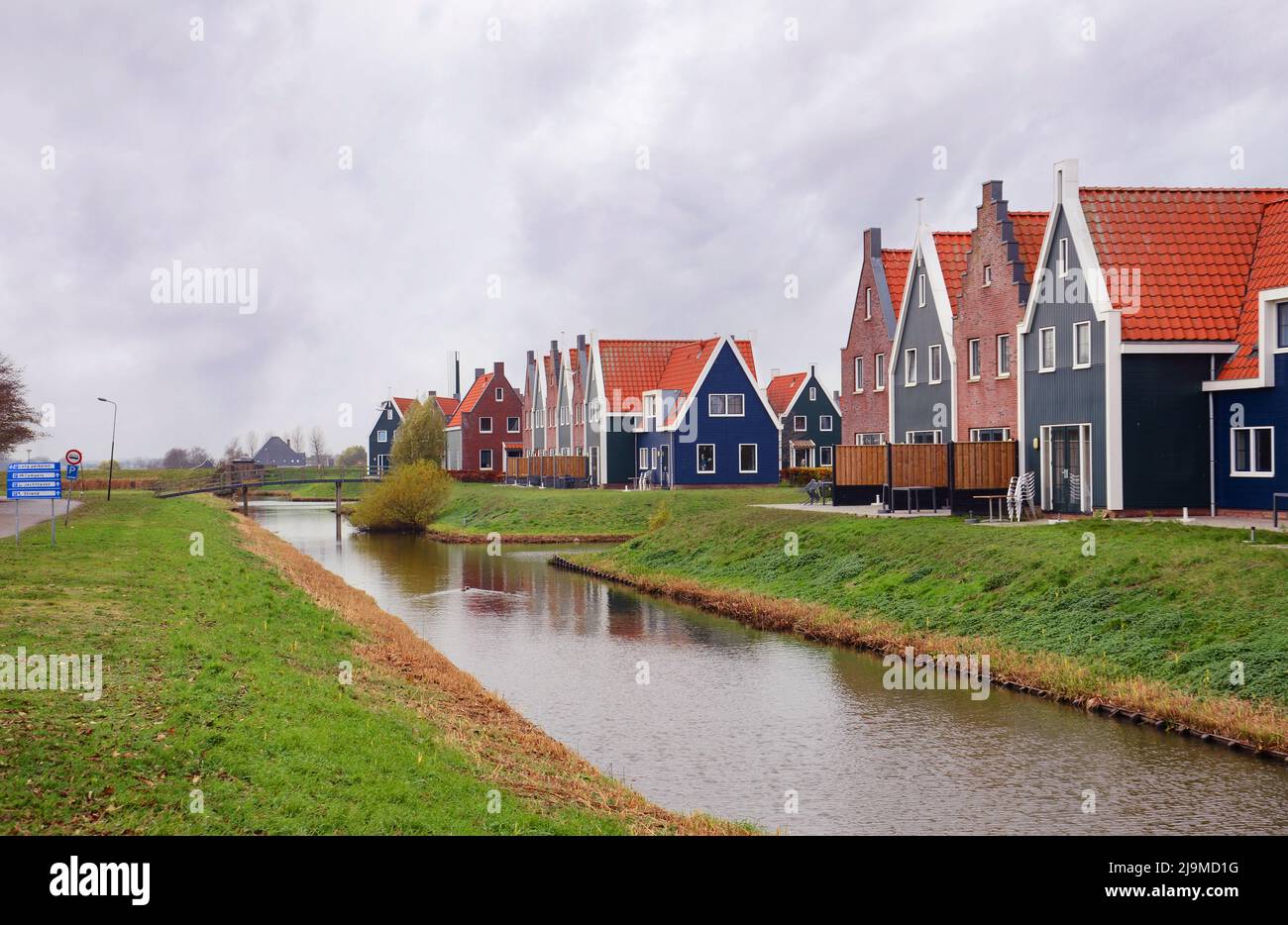 Beautiful Colored houses on riverside with bridge and windmills in ...