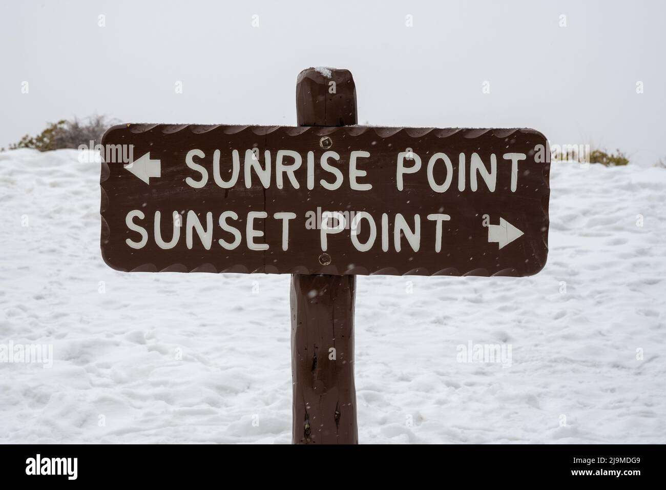 Sign points toward Sunrise and sunset points on snowy day in Bryce ...