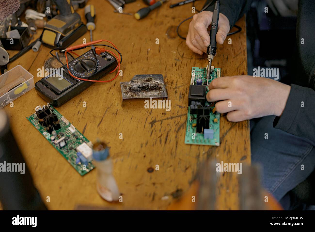 Close up of repairman hands is soldering circuit board of electronic device on the table Stock ...