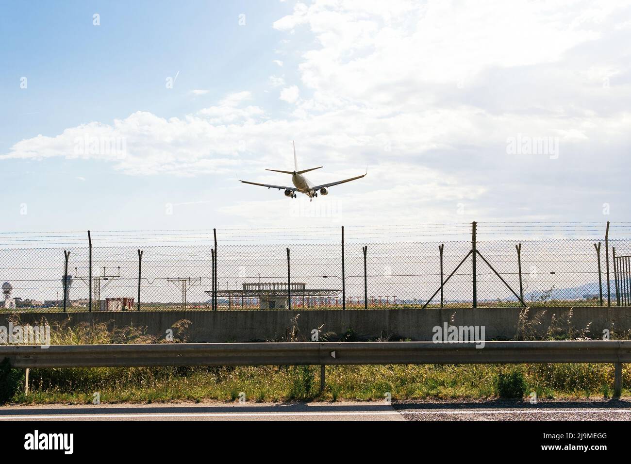 Modern airplane flying over runway and landing on runway in airport ...