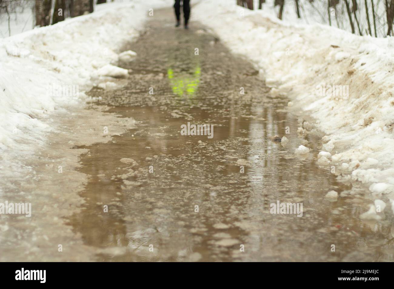 Road flooded. Snow in park. Large puddle in pedestrian zone. Obstacle ...
