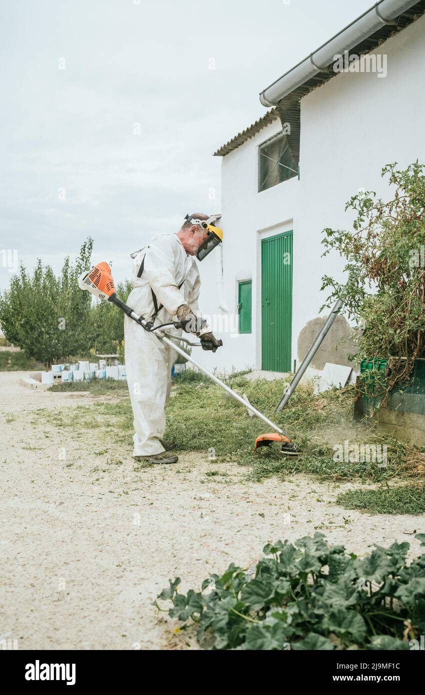 Full body side view of aged unrecognizable male farmer in white ...