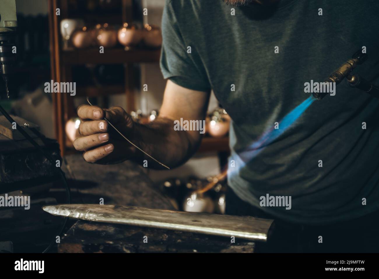 Cropped unrecognizable craftsman using gas torch to burn detail while ...