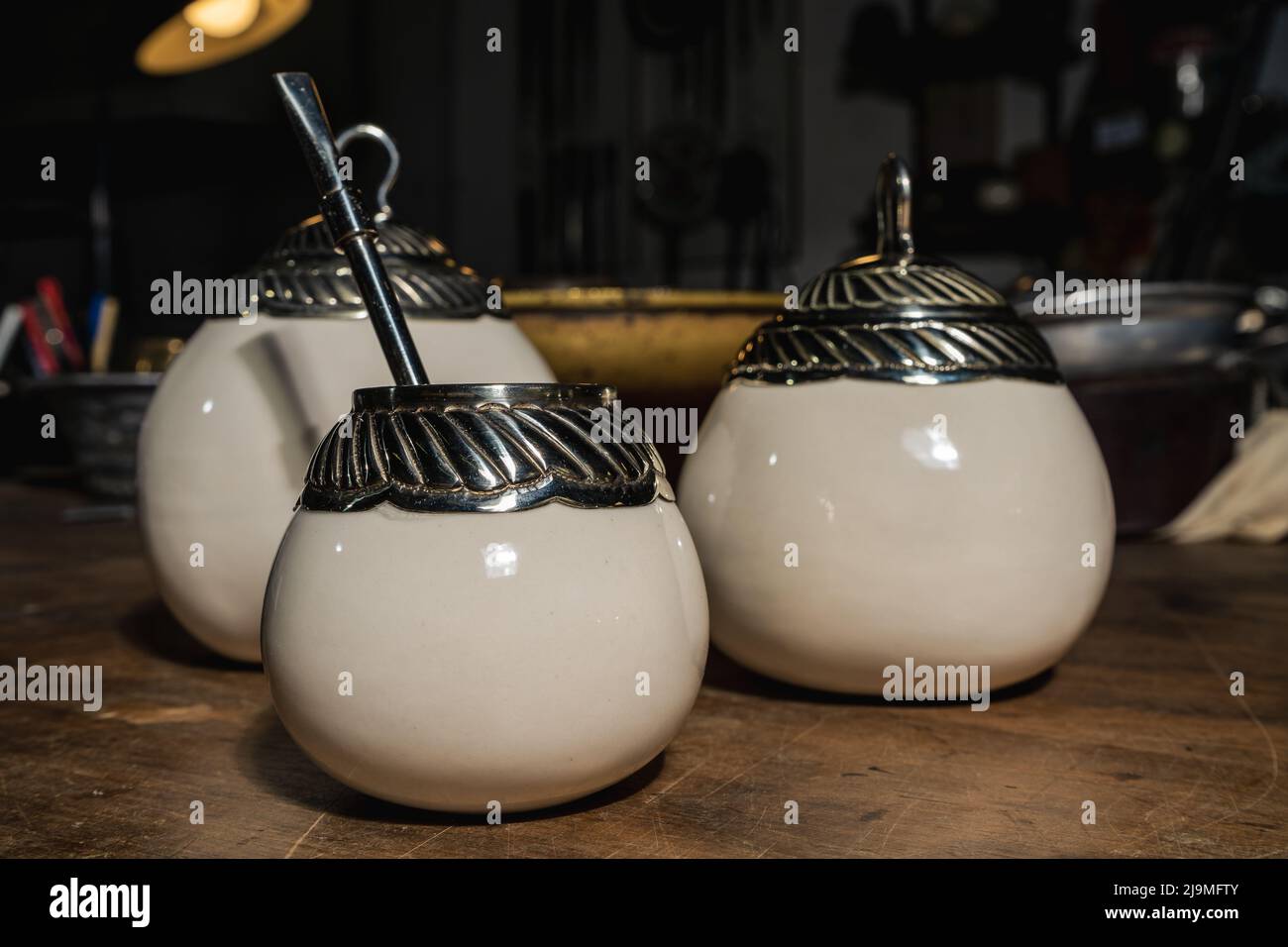 White ceramic mate cups decorated with silver rims and lids ...