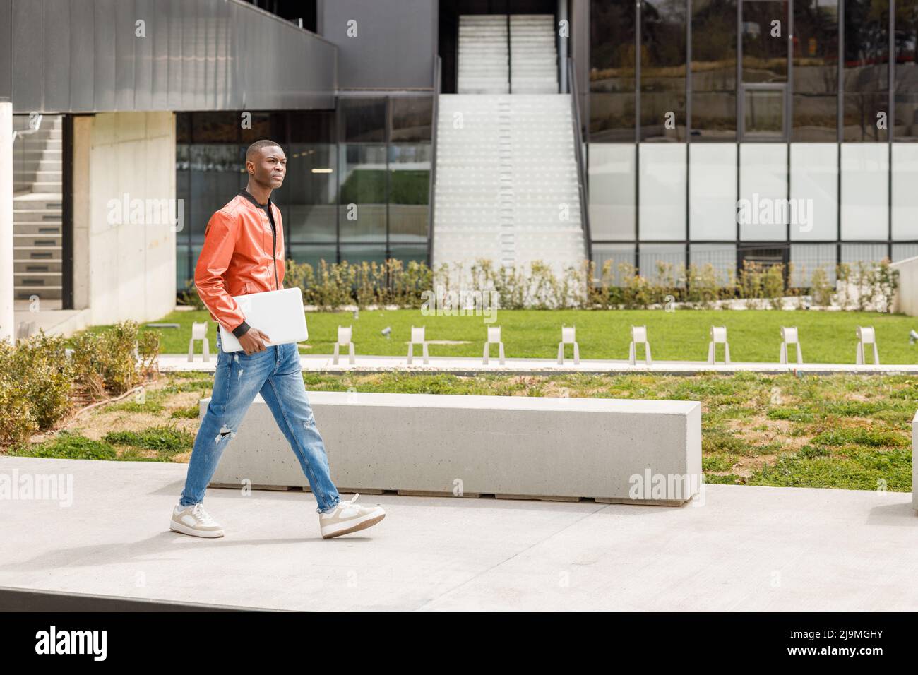 Full length side view of young stylish black male student in trendy ...