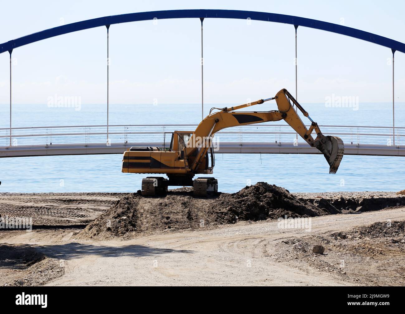 excavation and earthmoving machinery, bulldozer with bridge and sea in ...